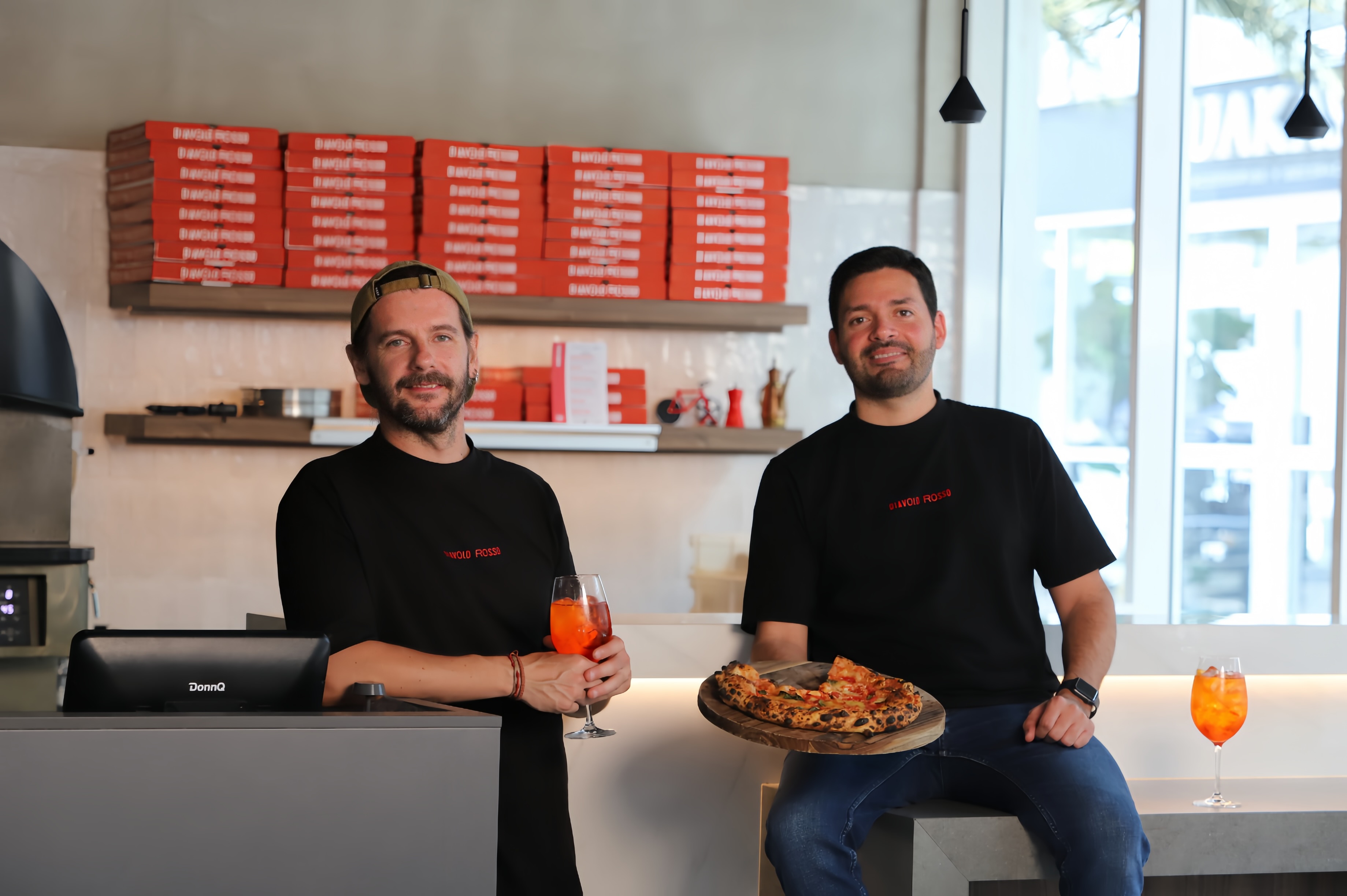 Giovanni y Sebastián encienden las pizzas de Diavolo Rosso